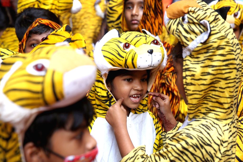 Children wearing tiger costumes participate in an awareness programme ...