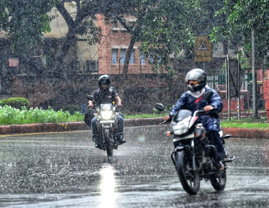 Commuters make their way during rain