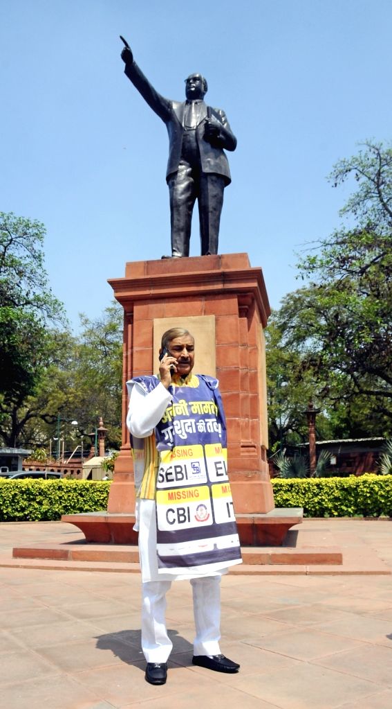 Congress MP Pramod Tiwari wearing a poster stand near Ambedkar statue