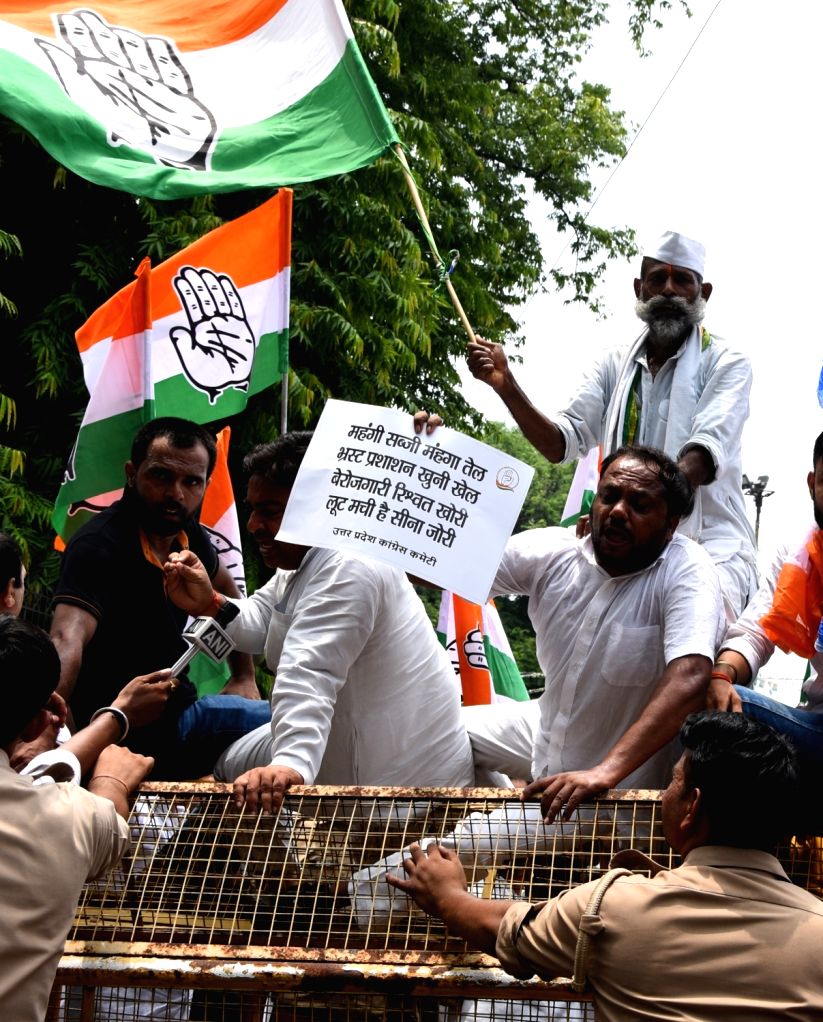 Congress workers hold party flags and a placard during a protest