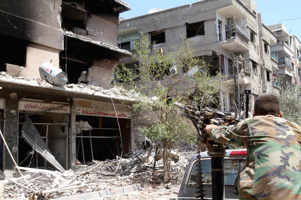 A Syrian soldier looks on at al-Mleiha town in the outskirts of Damascus