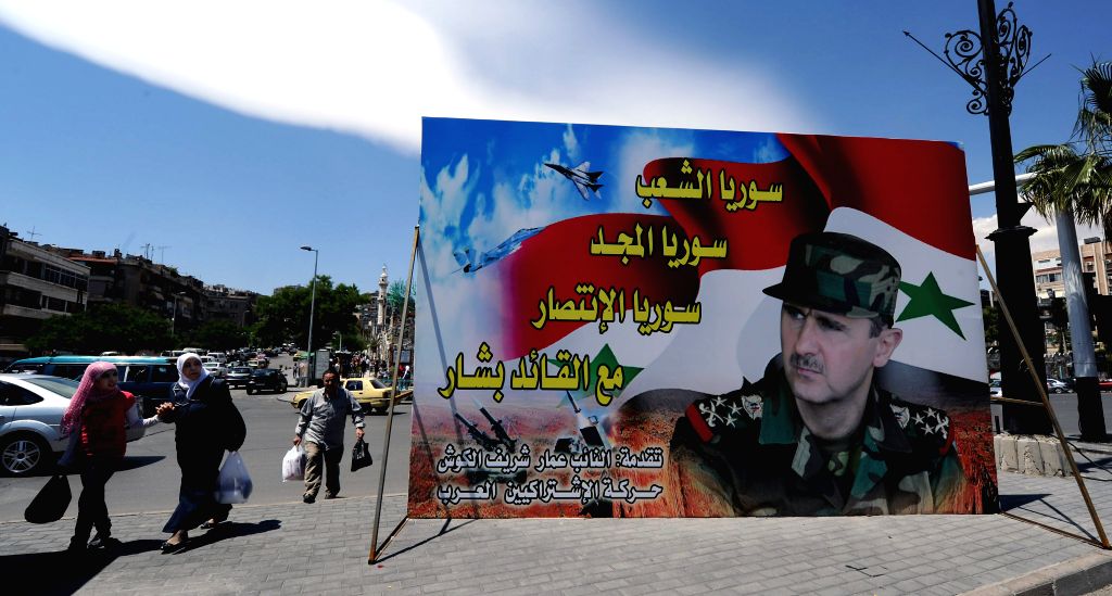People walk past an election campaign billboard of incumbent President ...