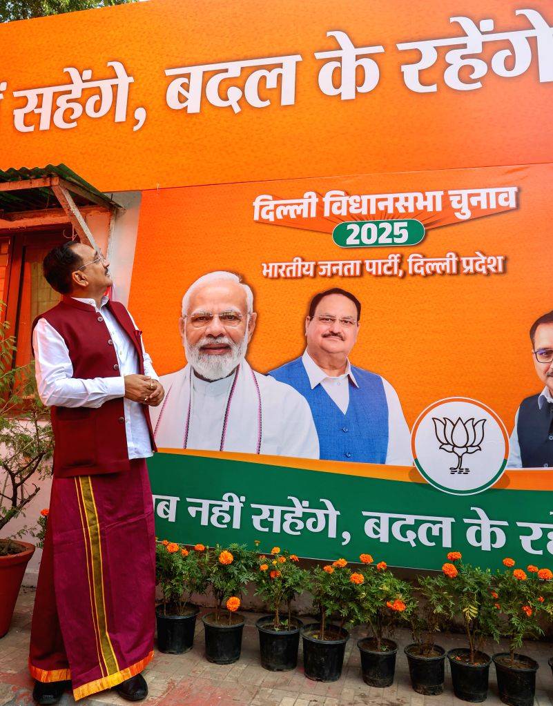 Delhi BJP President Virendra Sachdeva poses with posters of 'Ab Nahi ...