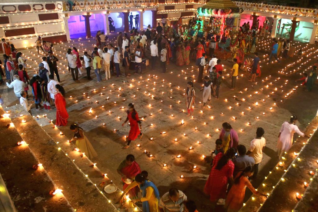 Devotees light the earthen lamps to celebrate Laksha Deepotsava