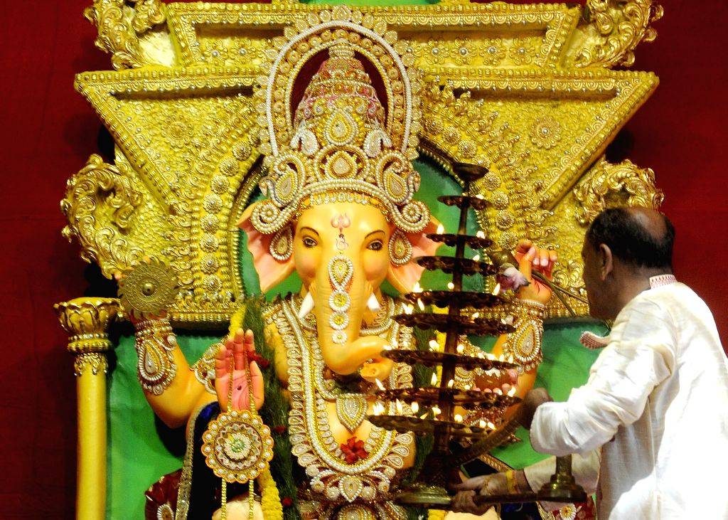 Devotees perform rituals before the idol of Lord Ganesha
