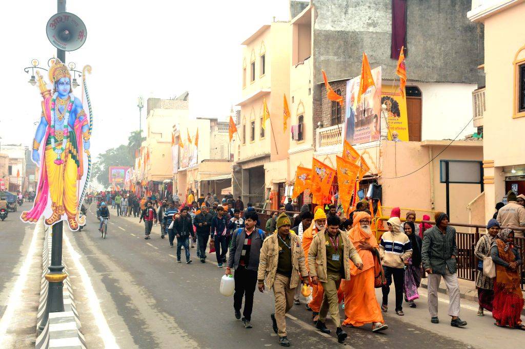 Devotees walk past Rampath ahead of the consecration ceremony of Ram Mandir