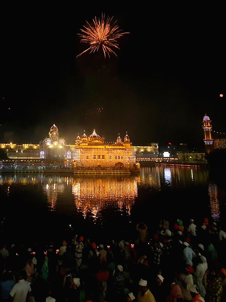 Devotees watch fireworks explode over the illuminated Golden Temple.