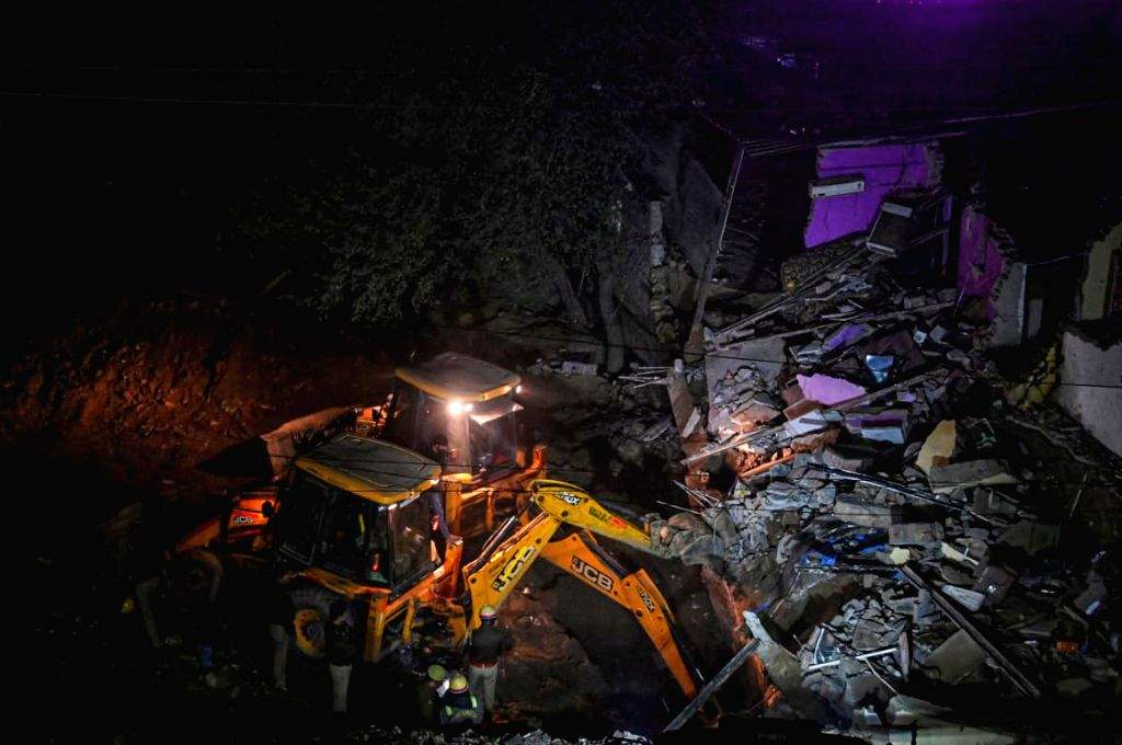 Excavators are used during the rescue operation after the wall of an ...