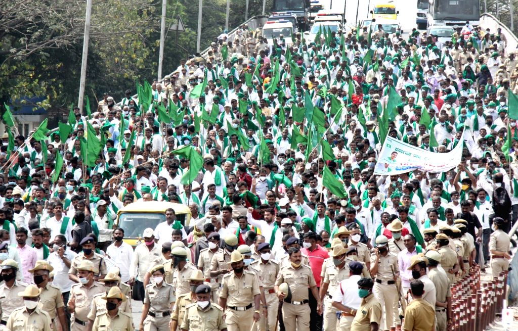 :Bengaluru:Farmers raise slogans as they march during a protest rally ...