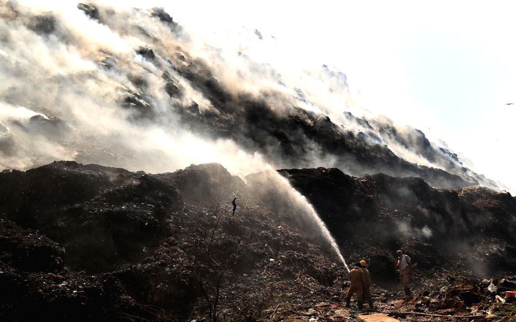 :New Delhi:Fire fighters try to douse a fire that broke out at Bhalswa ...