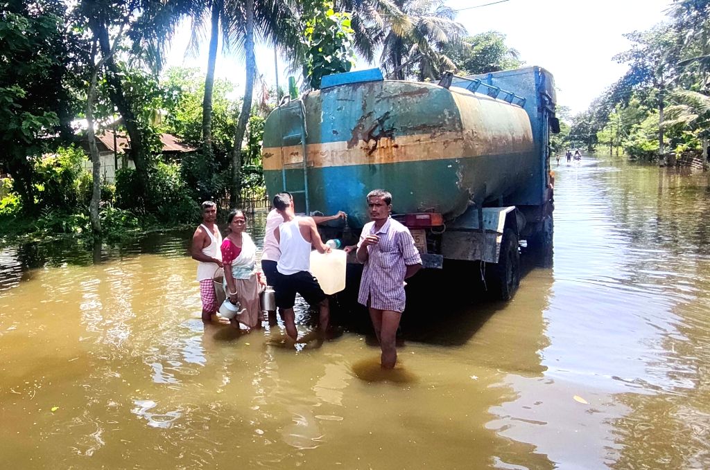 :Flood affected People collect drinking water from a truck.