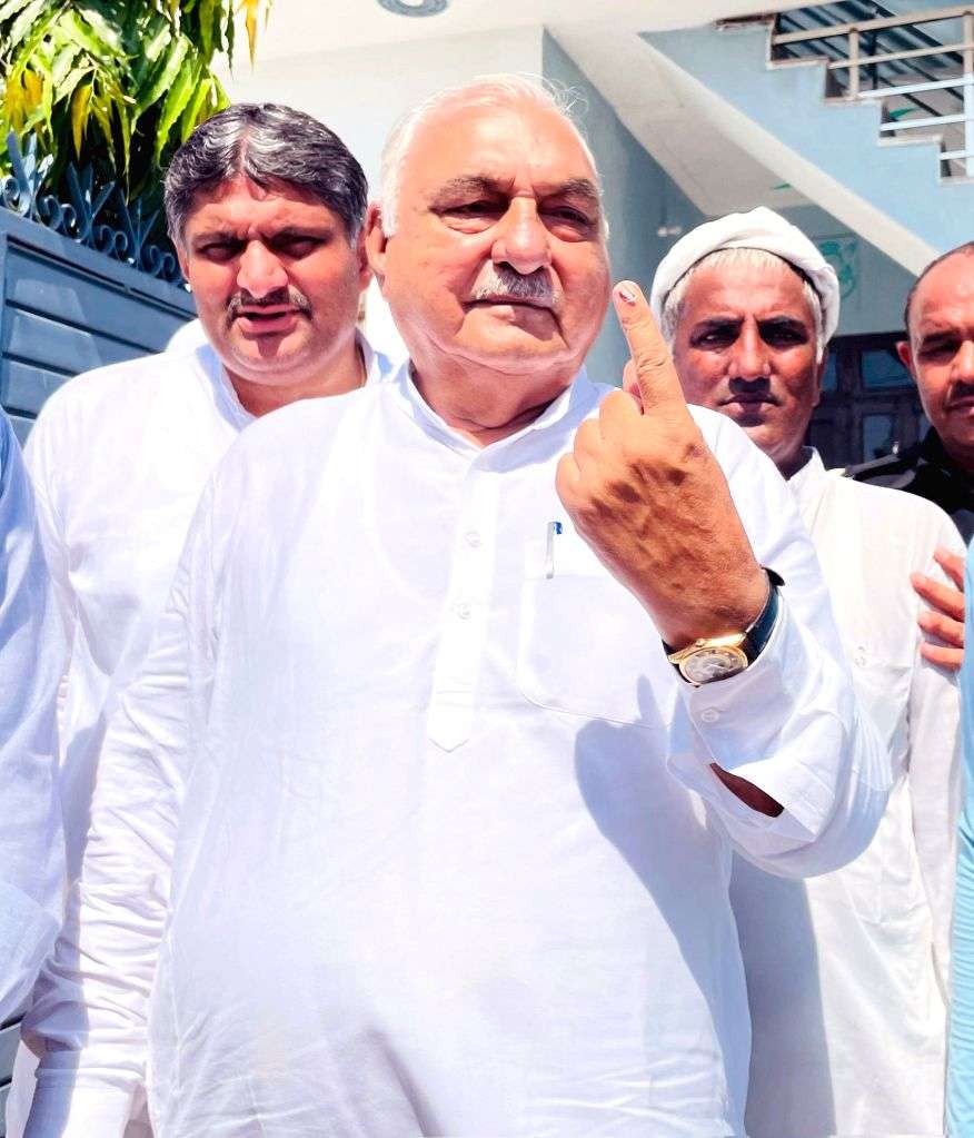 Former Haryana CM Bhupinder Singh Hooda shows his ink-marked finger
