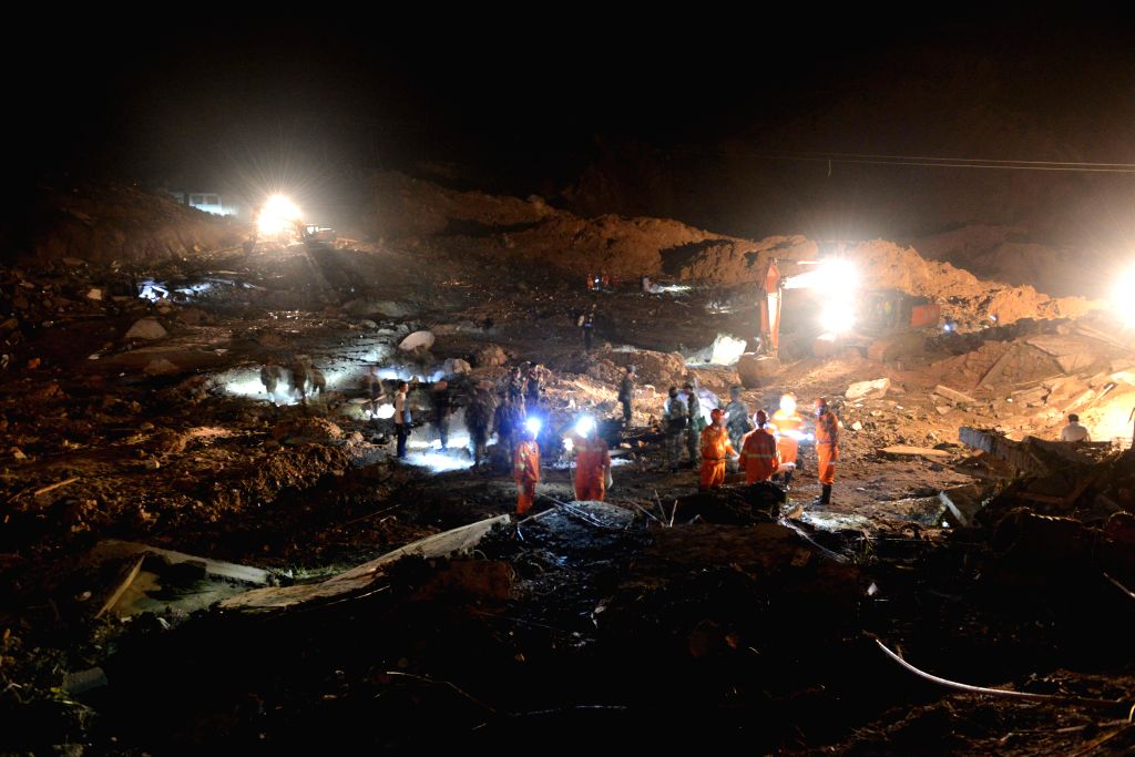 Rescuers work at the site of landslide