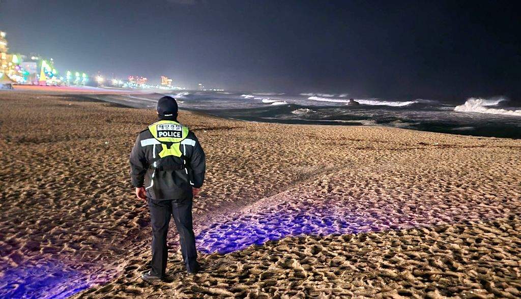 A maritime police officer patrols a beach in Gangneung as minor tsunami ...
