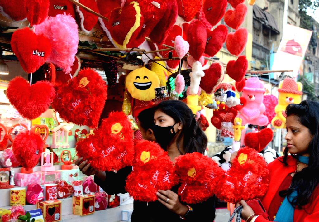 Girls buy reed heart soft toys from a shop on the eve of Valentine's Day