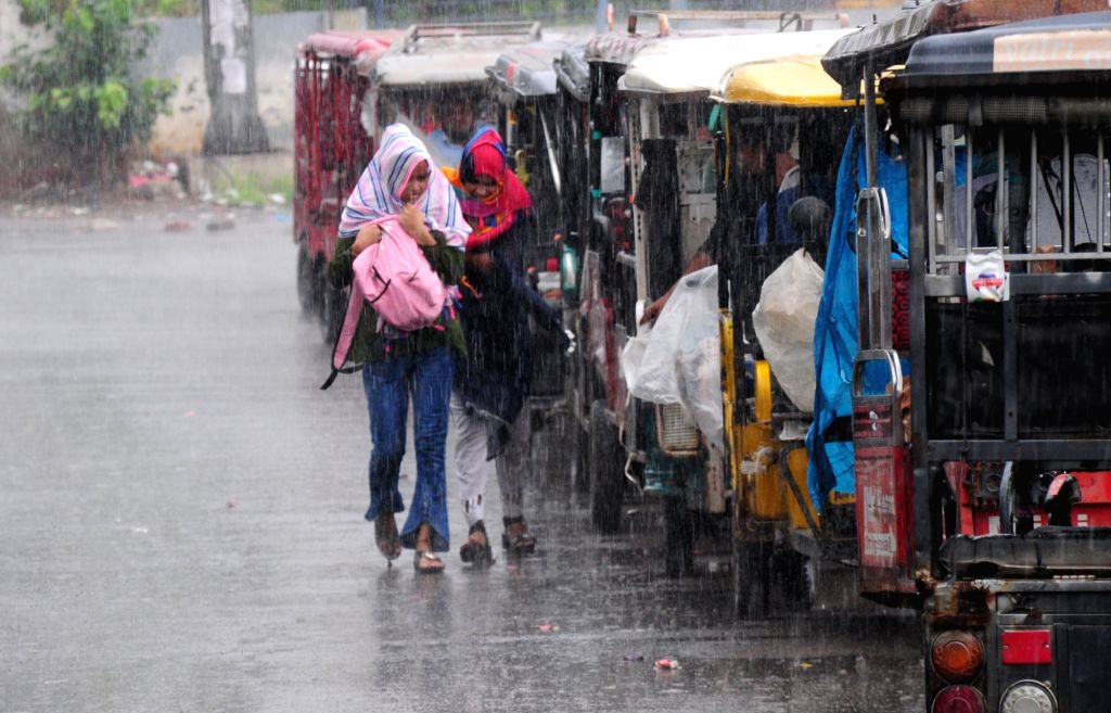 Girls make their way during heavy rain