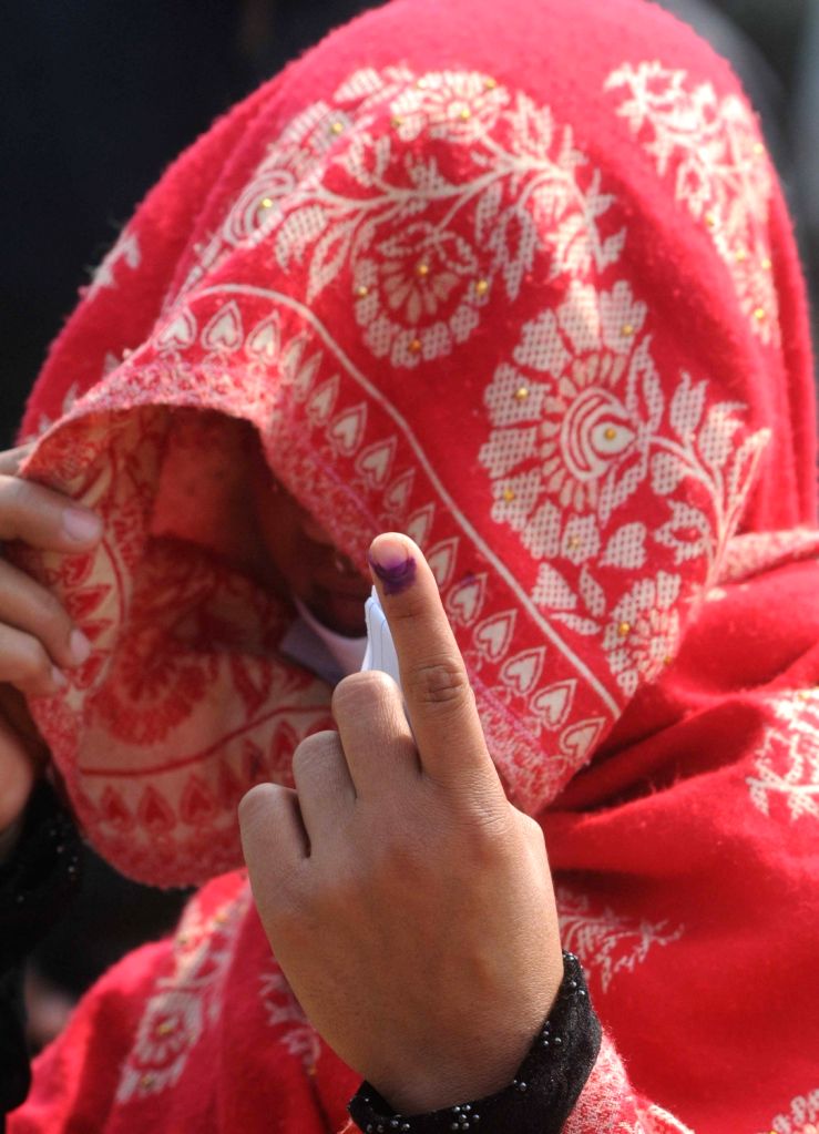 :Greater Noida:A woman displays her index finger after casting her vote.
