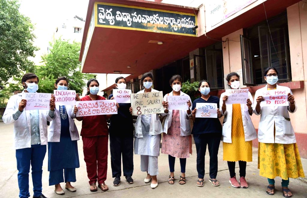 Government Hospitals Doctors and Nurses hold placards.