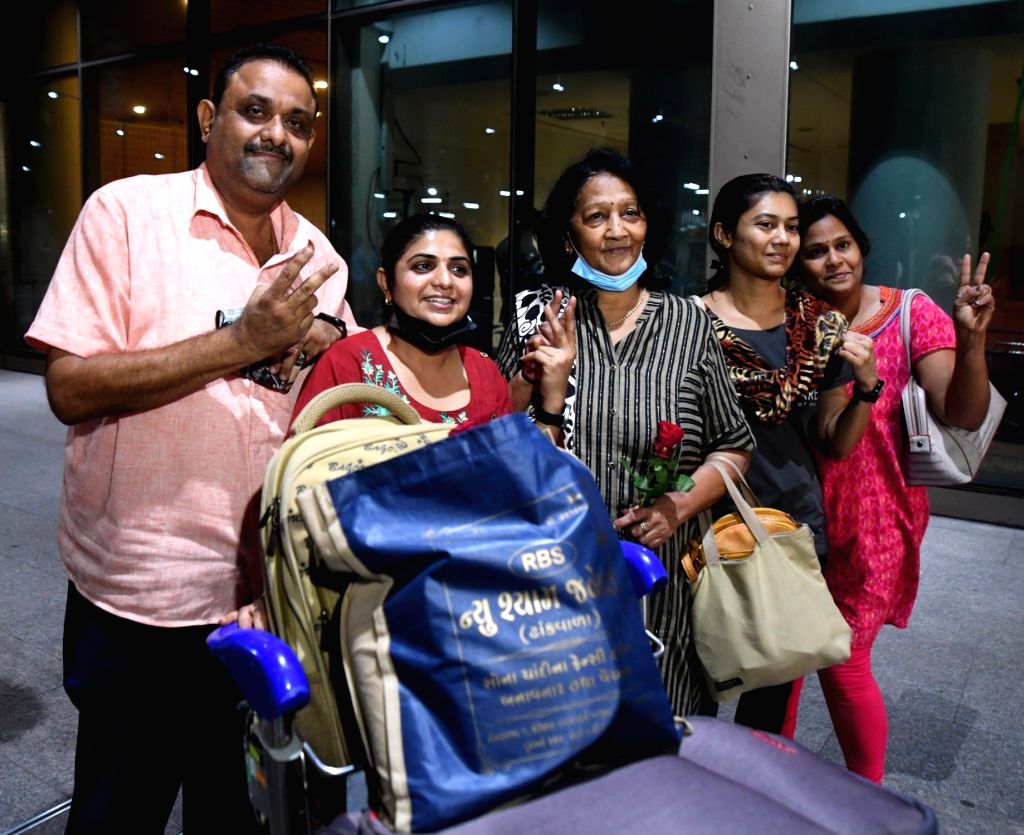 Indian Nationals show victory sign as they arrive at an Airport