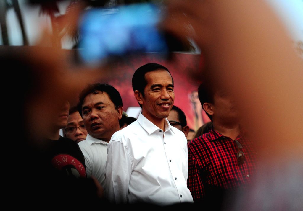 Joko Widodo smiles as he greets his supporters in Jakarta