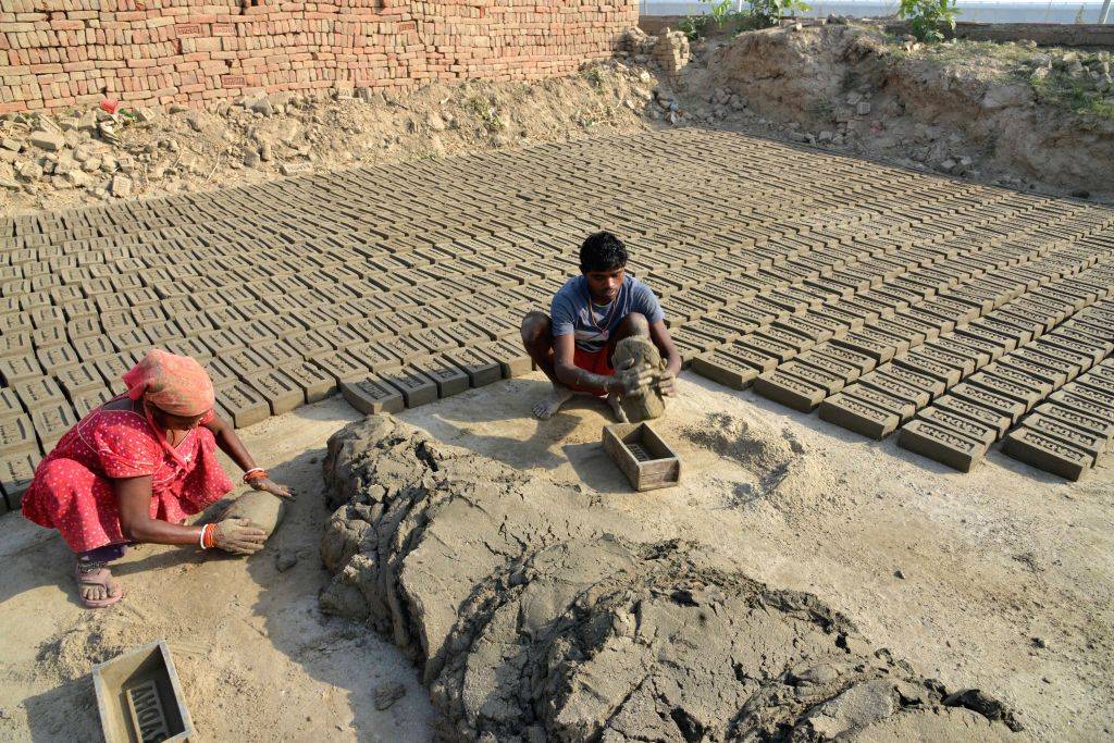 Labourers work at a brick factory on the eve of Labour Day