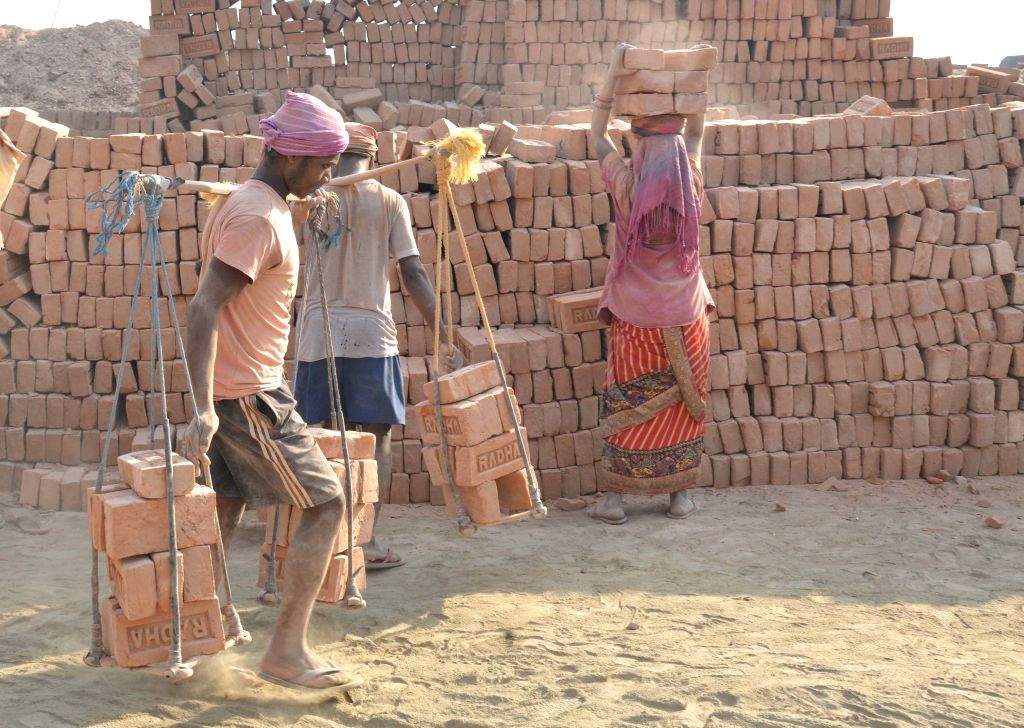 Labourers work at a brick factory on the eve of Labour Day