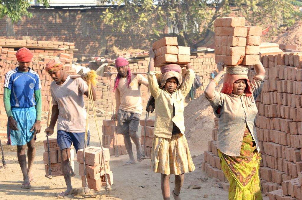 Labourers work at a brick factory on the eve of Labour Day