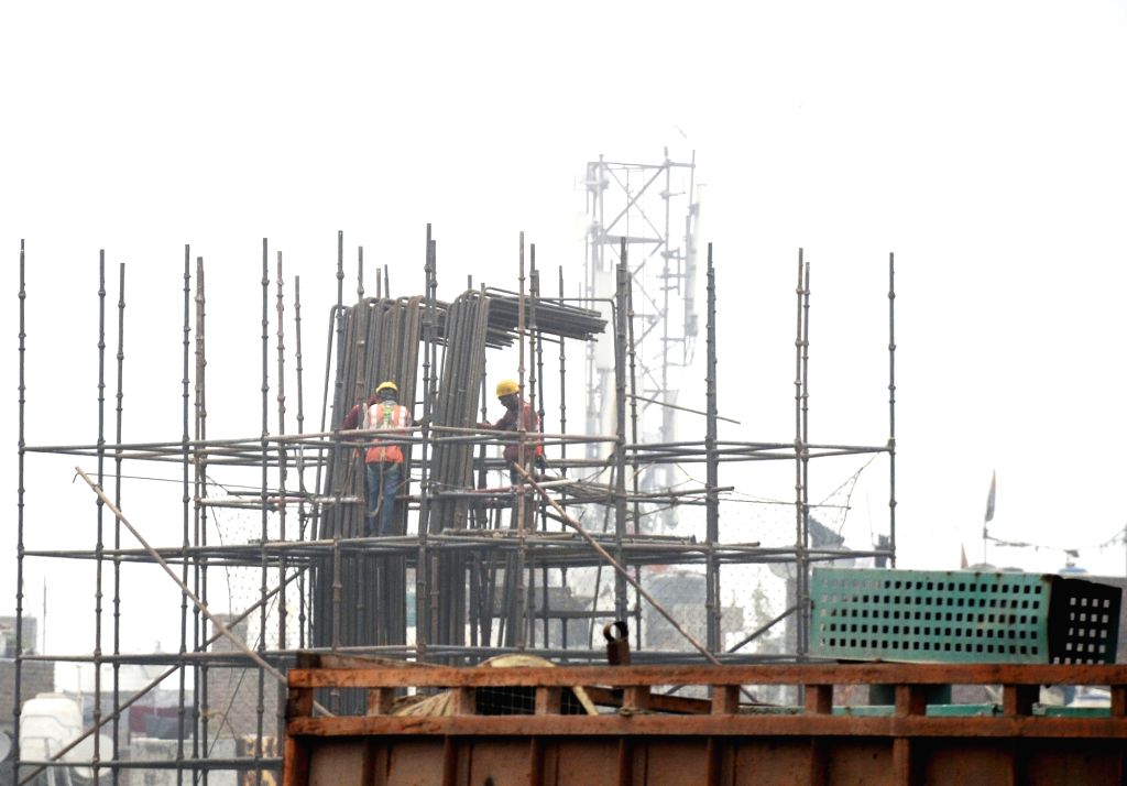 Labourers work at a construction site on a cold winter morning