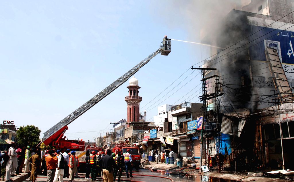 Fire fighters try to extinguish fire in eastern Pakistan's Lahore,