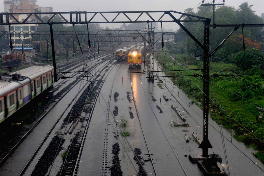 Local trains run through flooded railway tracks