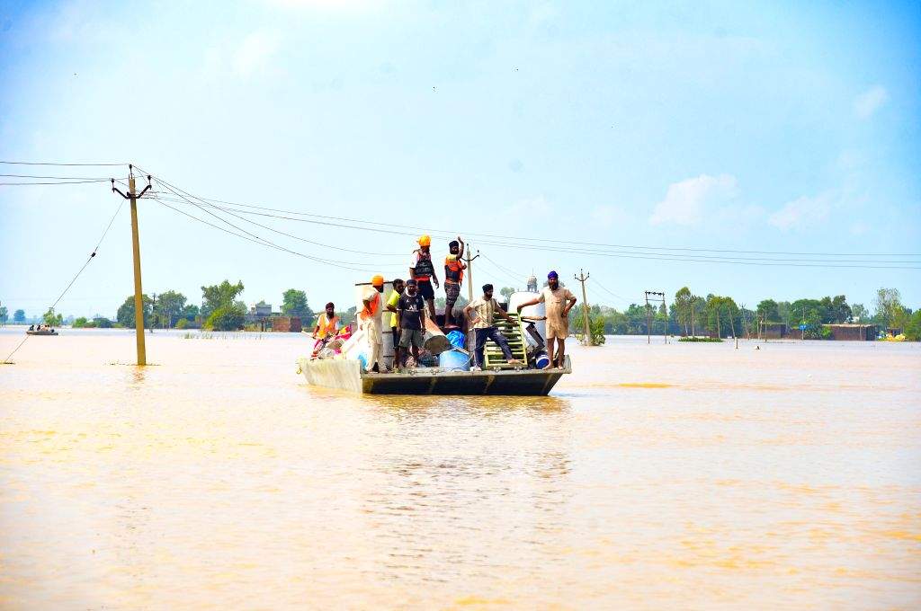 Locals evacuate through floodwaters of Beas River