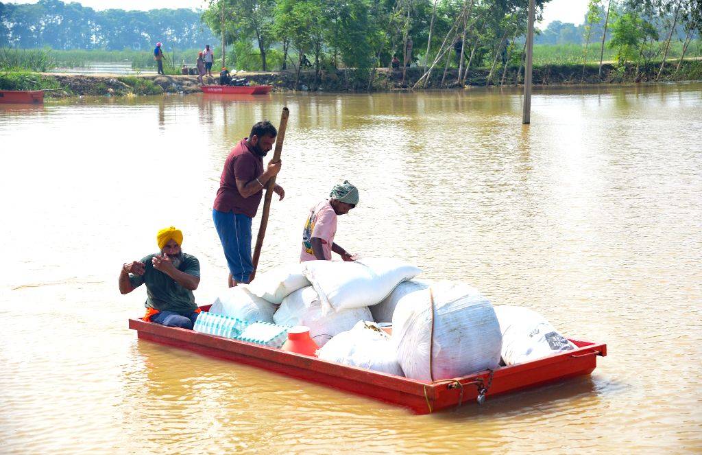 Locals evacuate through floodwaters of Beas River