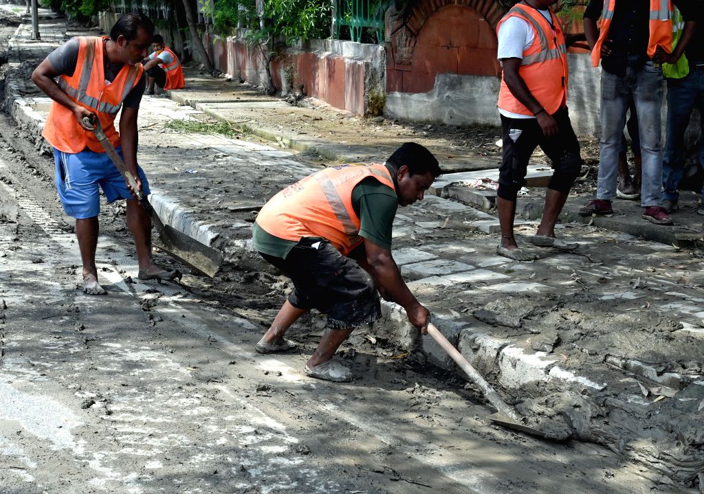 MCD workers clean debris from road as the Yamuna floodwater continues ...
