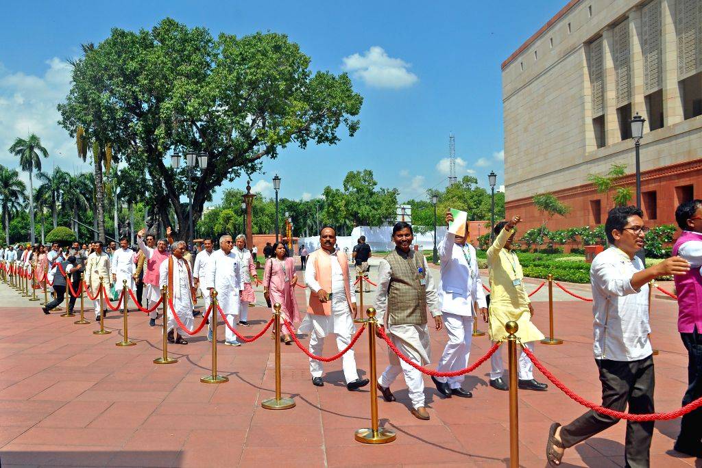 Members of Parliament walk towards the new Parliament