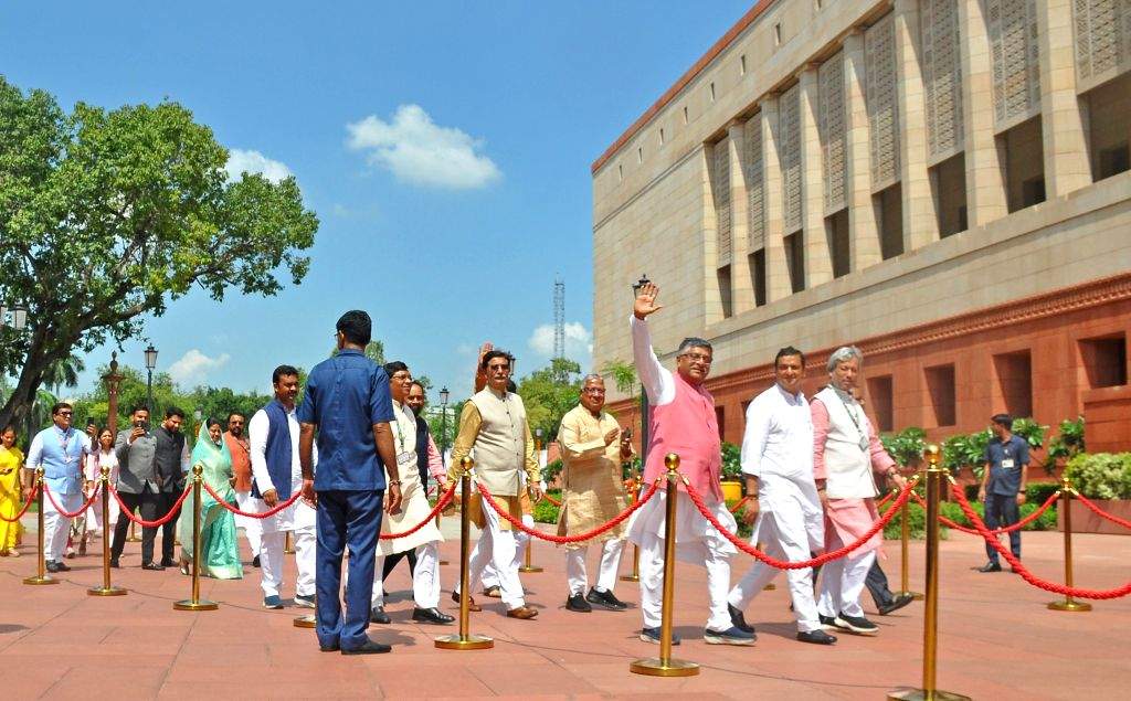 Members of Parliament walk towards the new Parliament