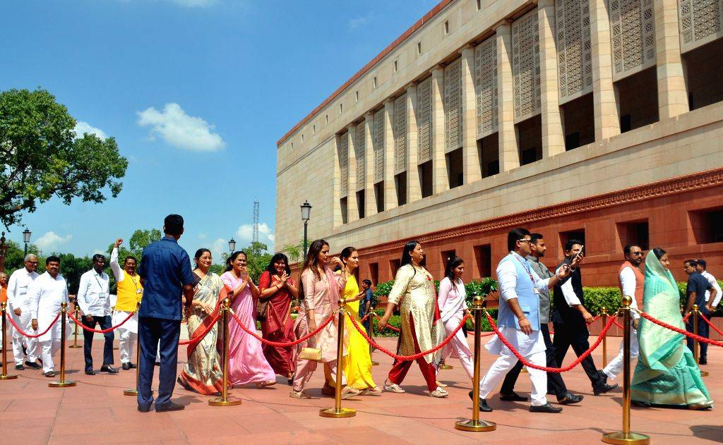 Members of Parliament walk towards the new Parliament