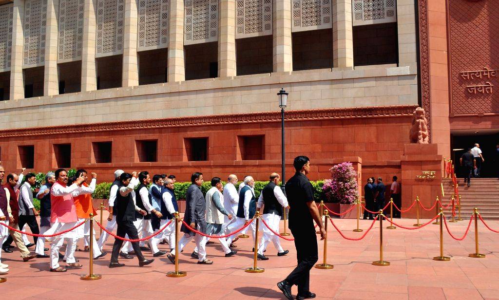 Members of Parliament walk towards the new Parliament