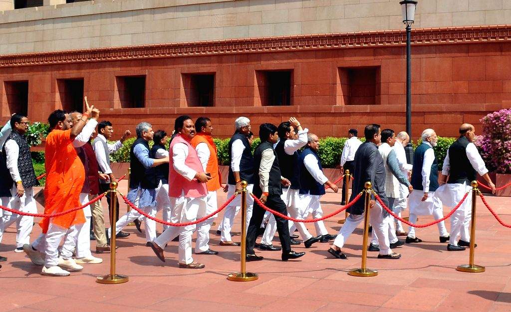 Members of Parliament walk towards the new Parliament