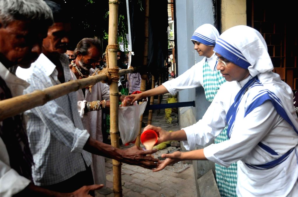 Missionaries of Charity nuns distribute bread and tea