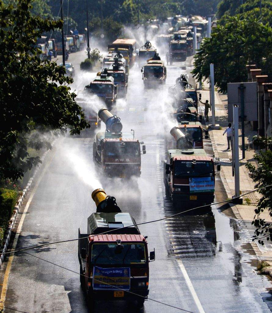 Mobile anti-smog guns spray water mist along roads in a campaign to ...