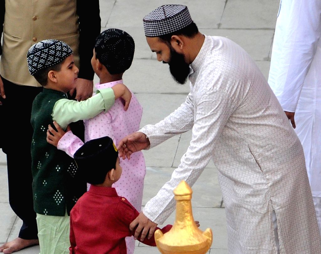 Muslim children greet each other after offering prayers on the occasion ...