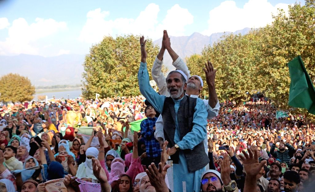 Muslim devotees pray as the head priest displays the holy relic