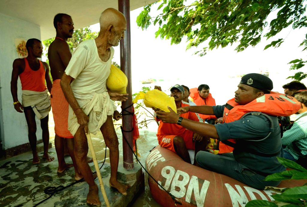NDRF personnel distribute food packets to flood victims