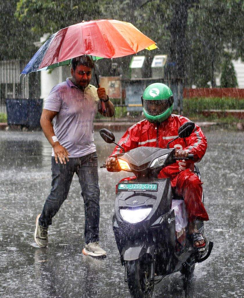 New Delhi : A man riding his bike amid heavy rain