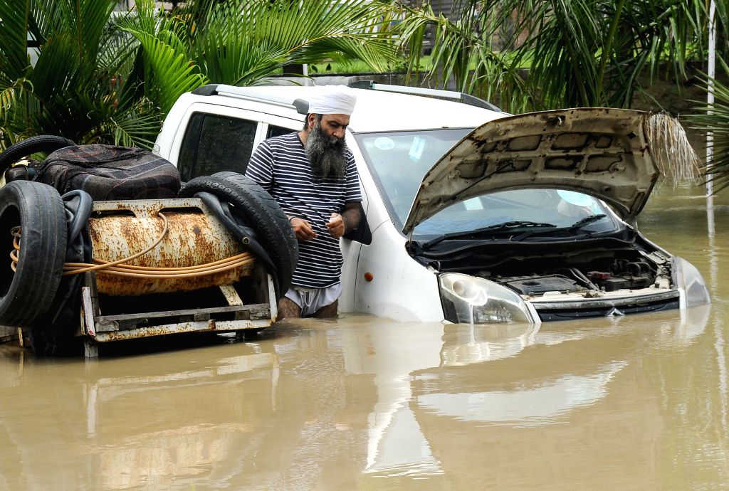 New Delhi : A man stands in floodwater in front of Namaskar Gurudwara