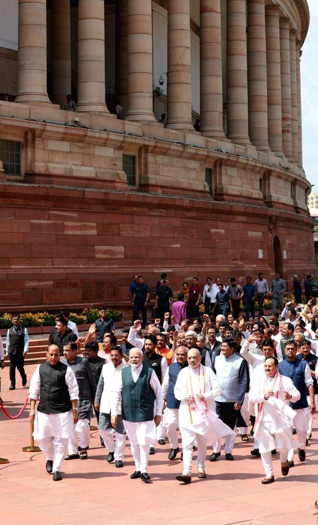 Parliamentarians walk from the old parliament to the new parliament ...