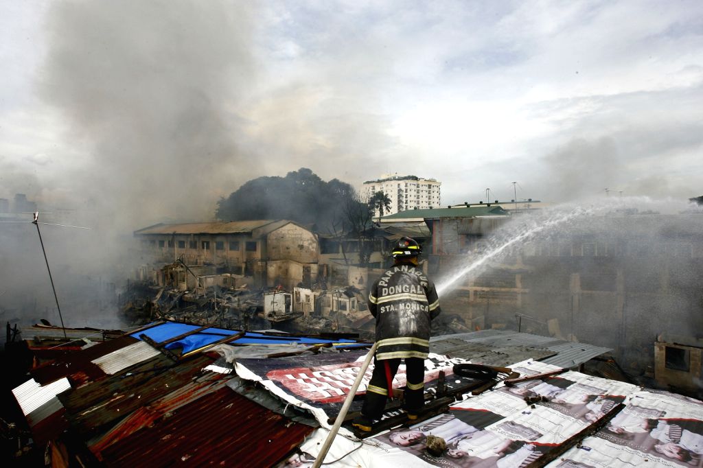 A firefighter tries to put out a fire that hit a slum area in Pasay City