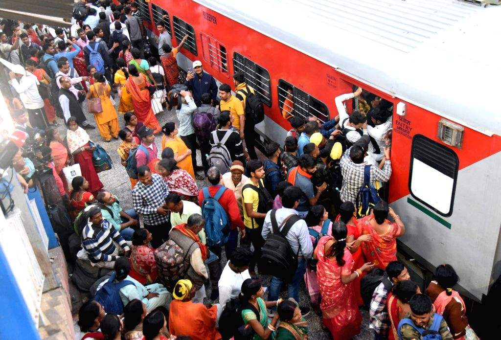 Passengers board a crowded train