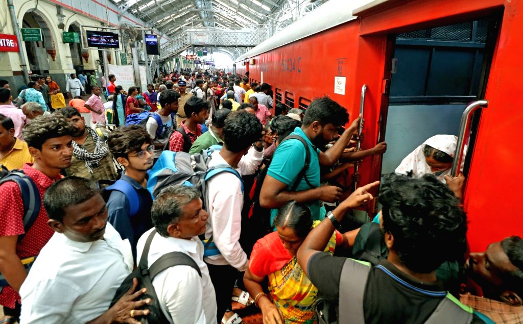 Passengers crowd board a train to visit their respective hometown