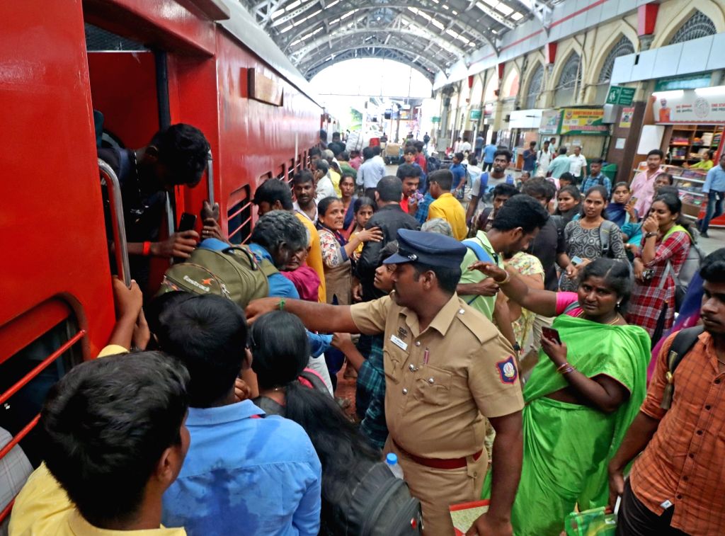 Passengers crowd board a train to visit their respective hometown